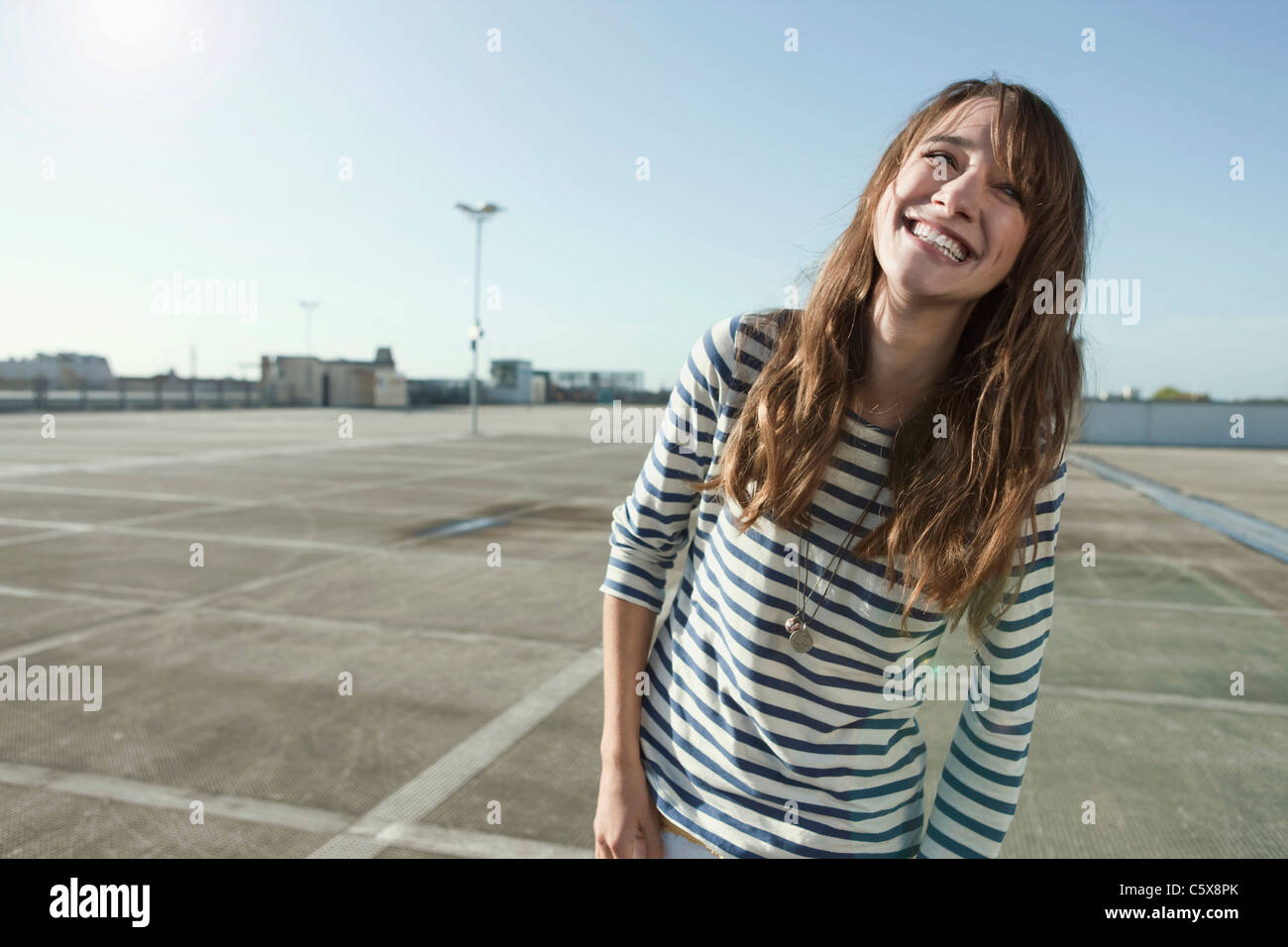 Germany, Berlin, Young woman on parking level, laughing, portrait Stock ...