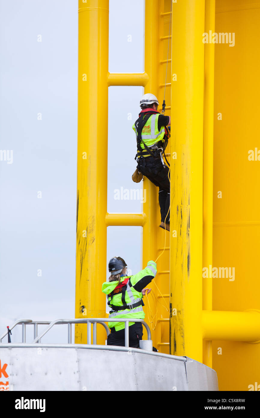 Offshore workers working on a wind turbine at the Walney Offshore ...