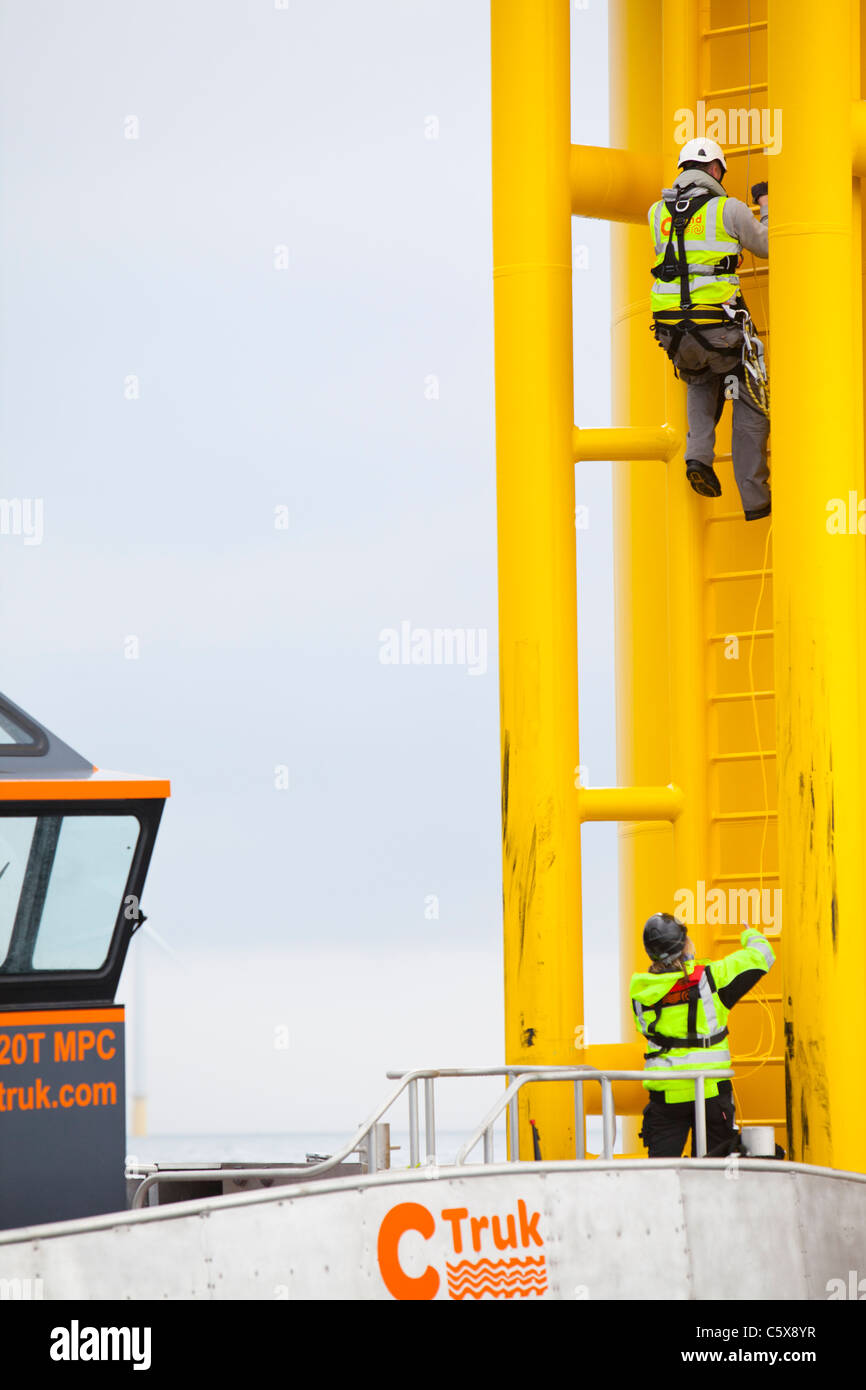 Offshore workers working on a wind turbine at the Walney Offshore ...