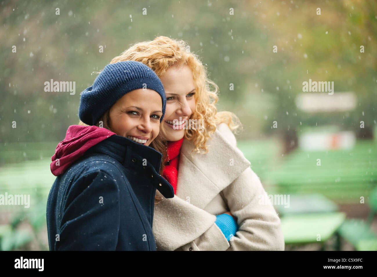Germany, Bavaria, English Garden, Two women in beer garden, laughing ...