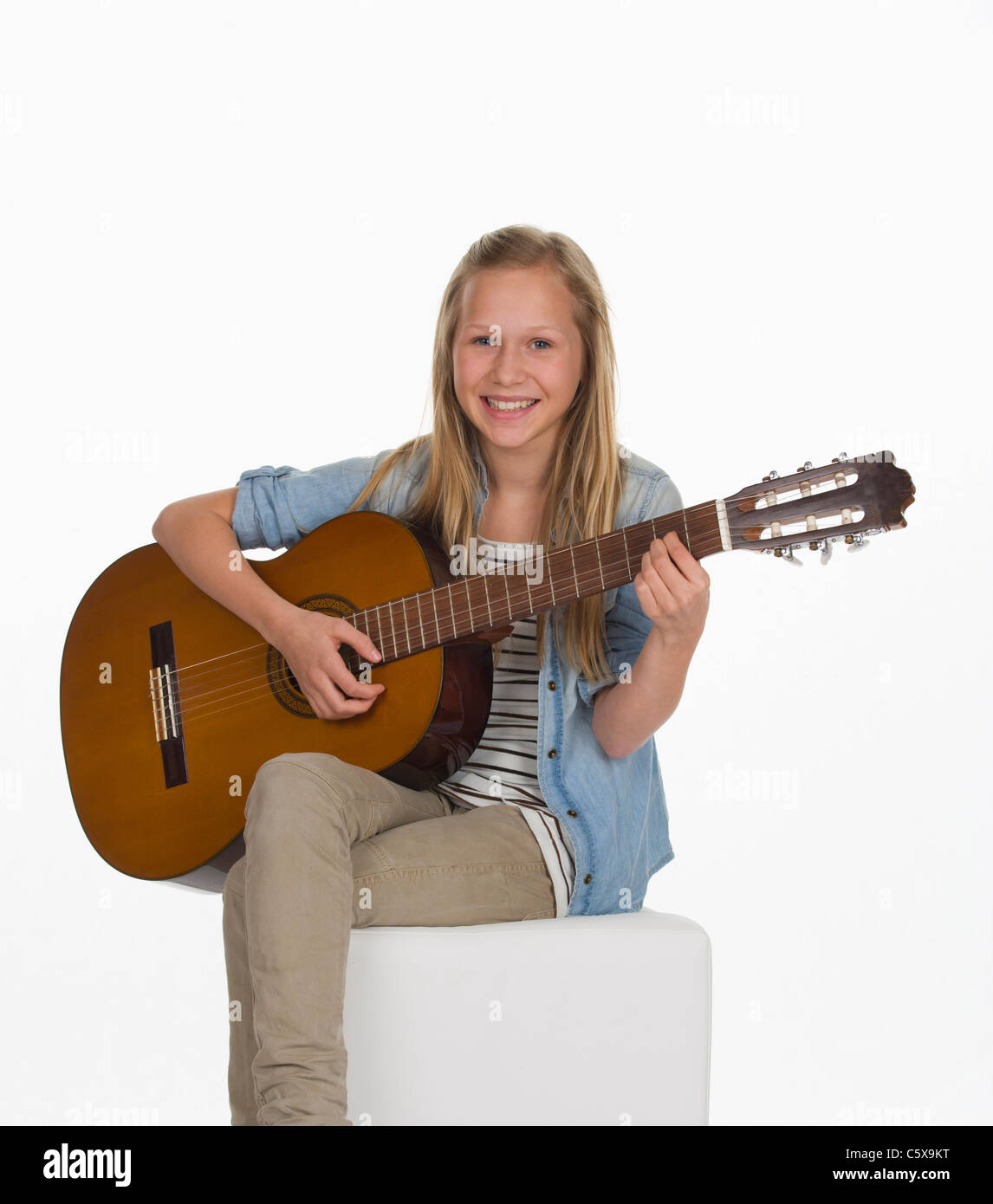 Girl playing guitar against white background, smiling, portrait Stock ...
