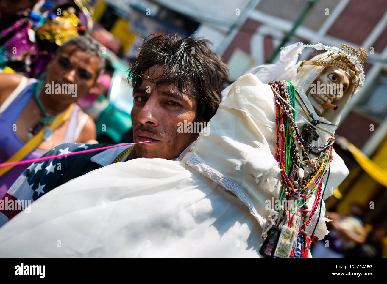 A Mexican follower of Santa Muerte (Saint Death) holds a sacred statue ...