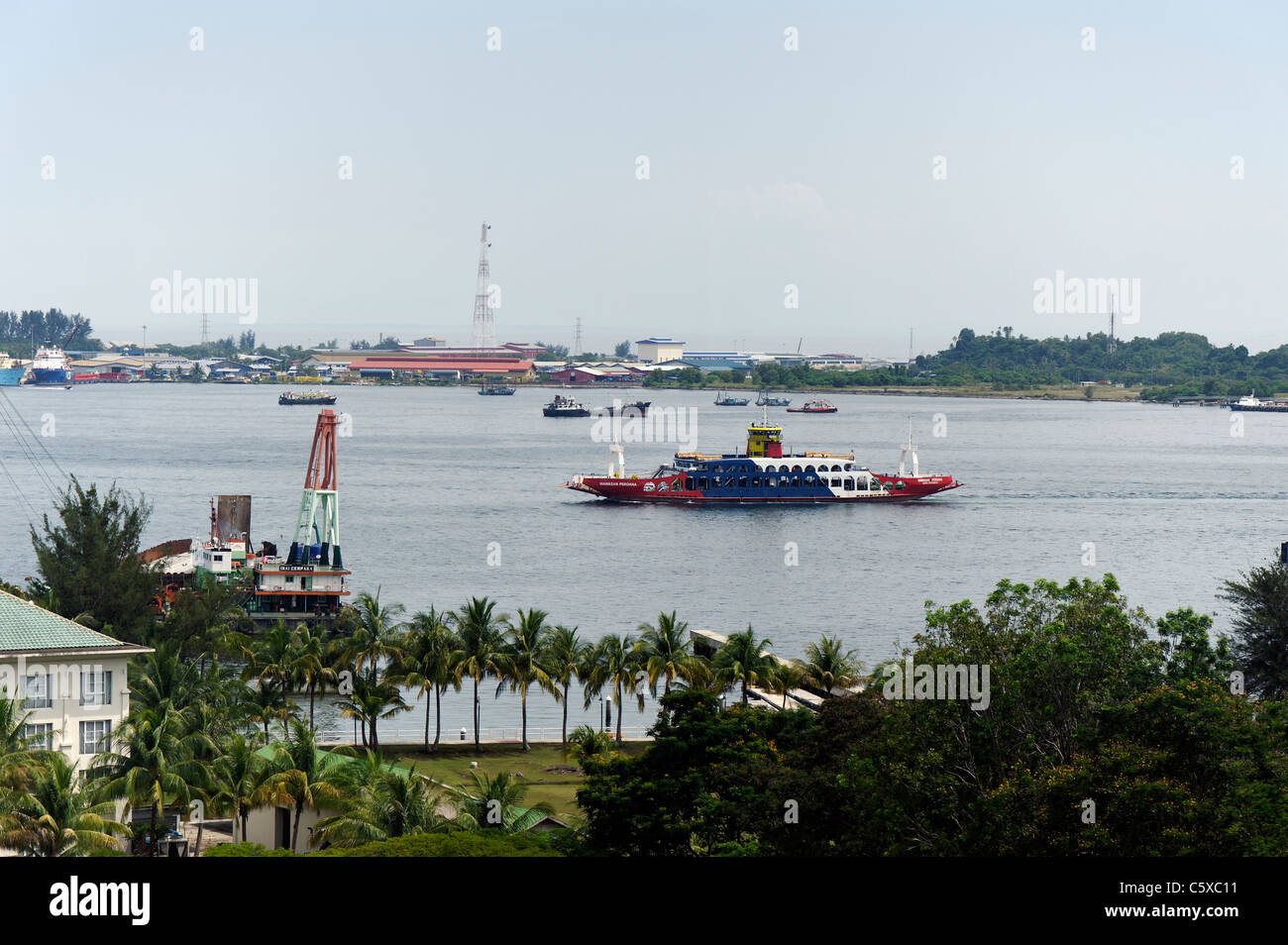 A ferry passing shipping and boats in Labuan, Malaysia Stock Photo - Alamy