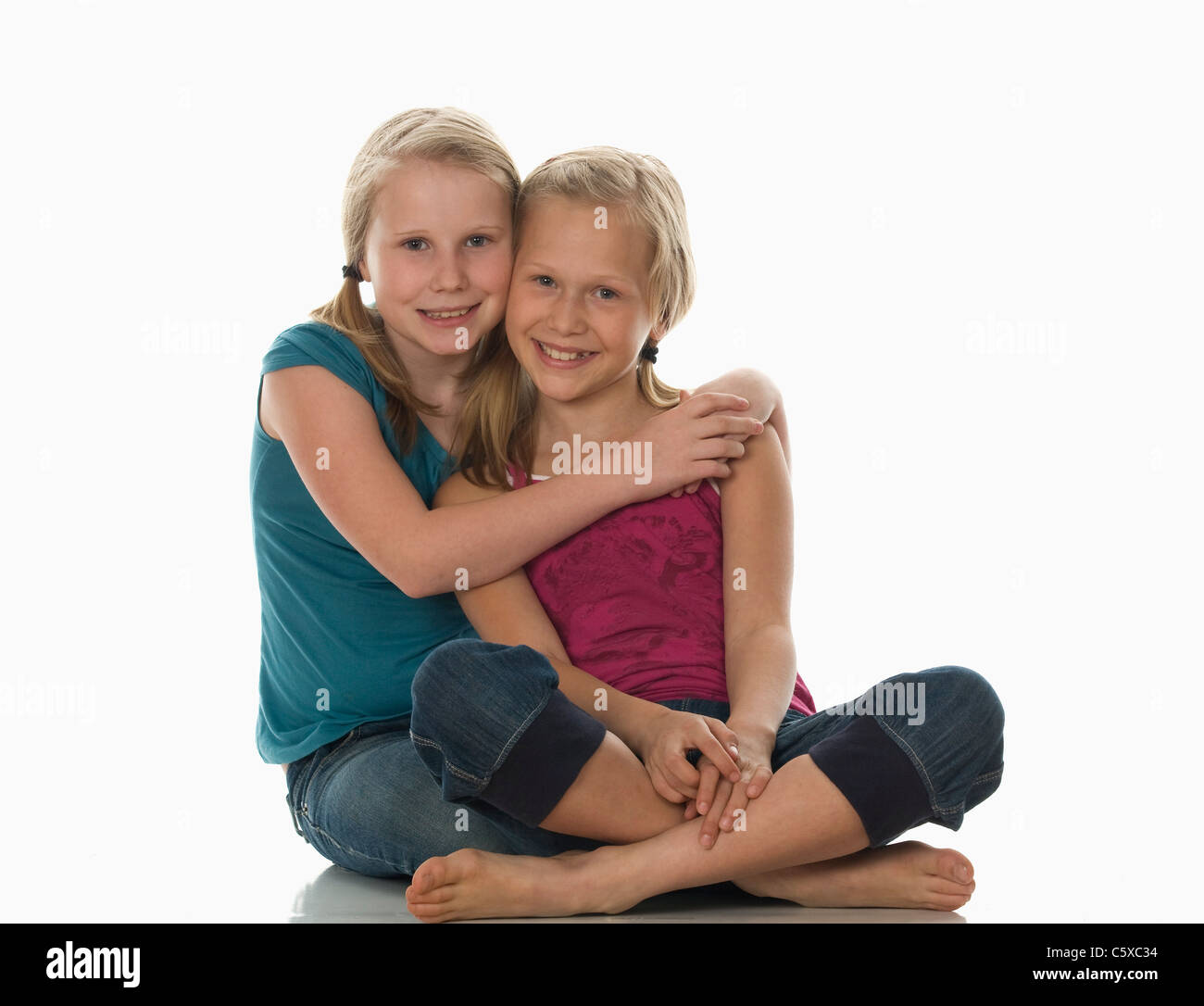 Two girls (10-11) embracing, smiling, portrait Stock Photo - Alamy