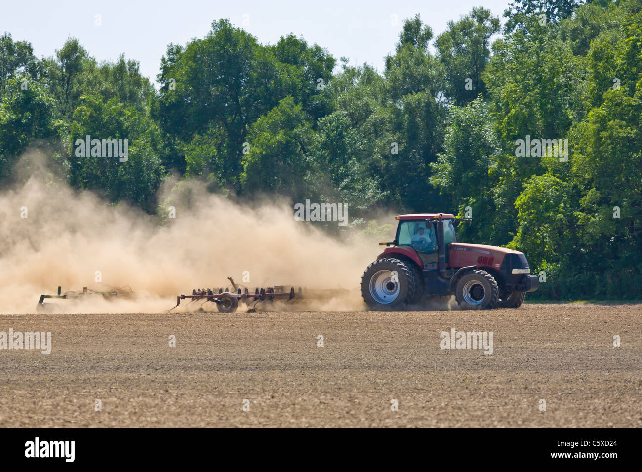 Tractor in dry dusty farm field Stock Photo - Alamy