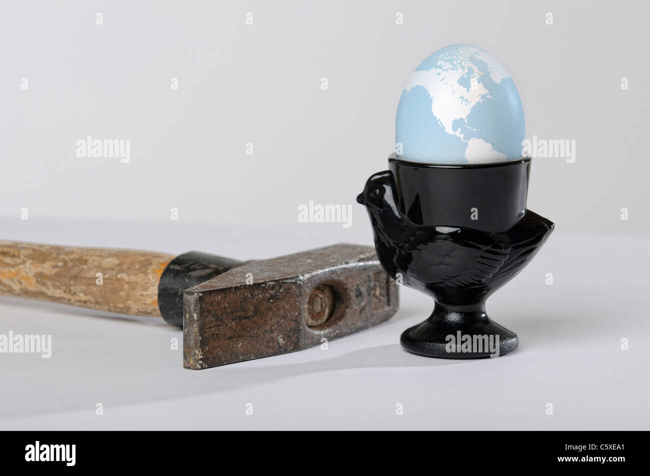 Fragility of the earth demonstrated with hammer and egg Stock Photo - Alamy
