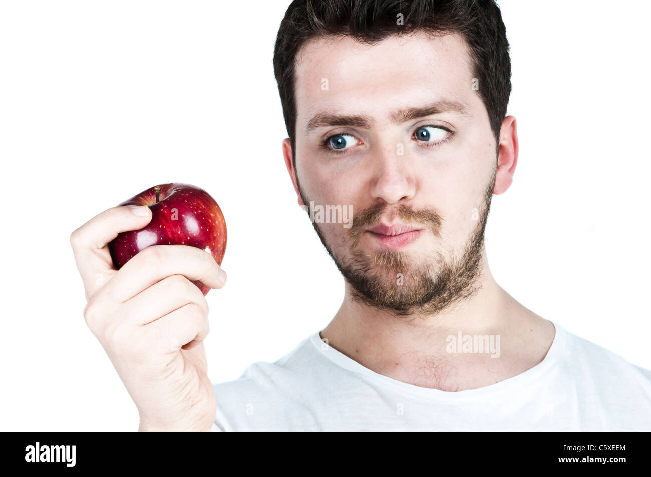 Isolated image of a young man staring at a red apple with hunger Stock ...