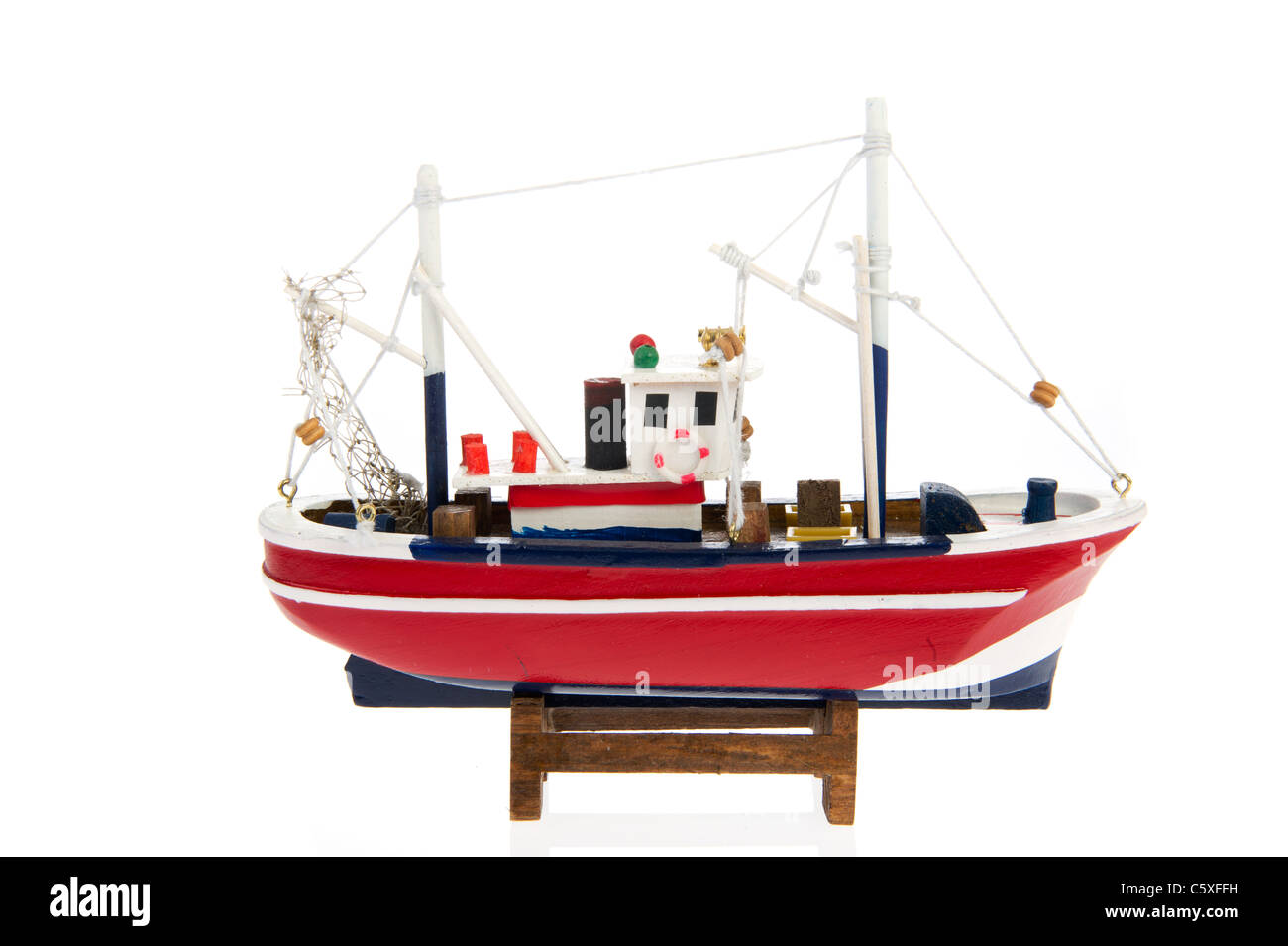 Wooden miniature fishing trawler boat isolated over white background ...