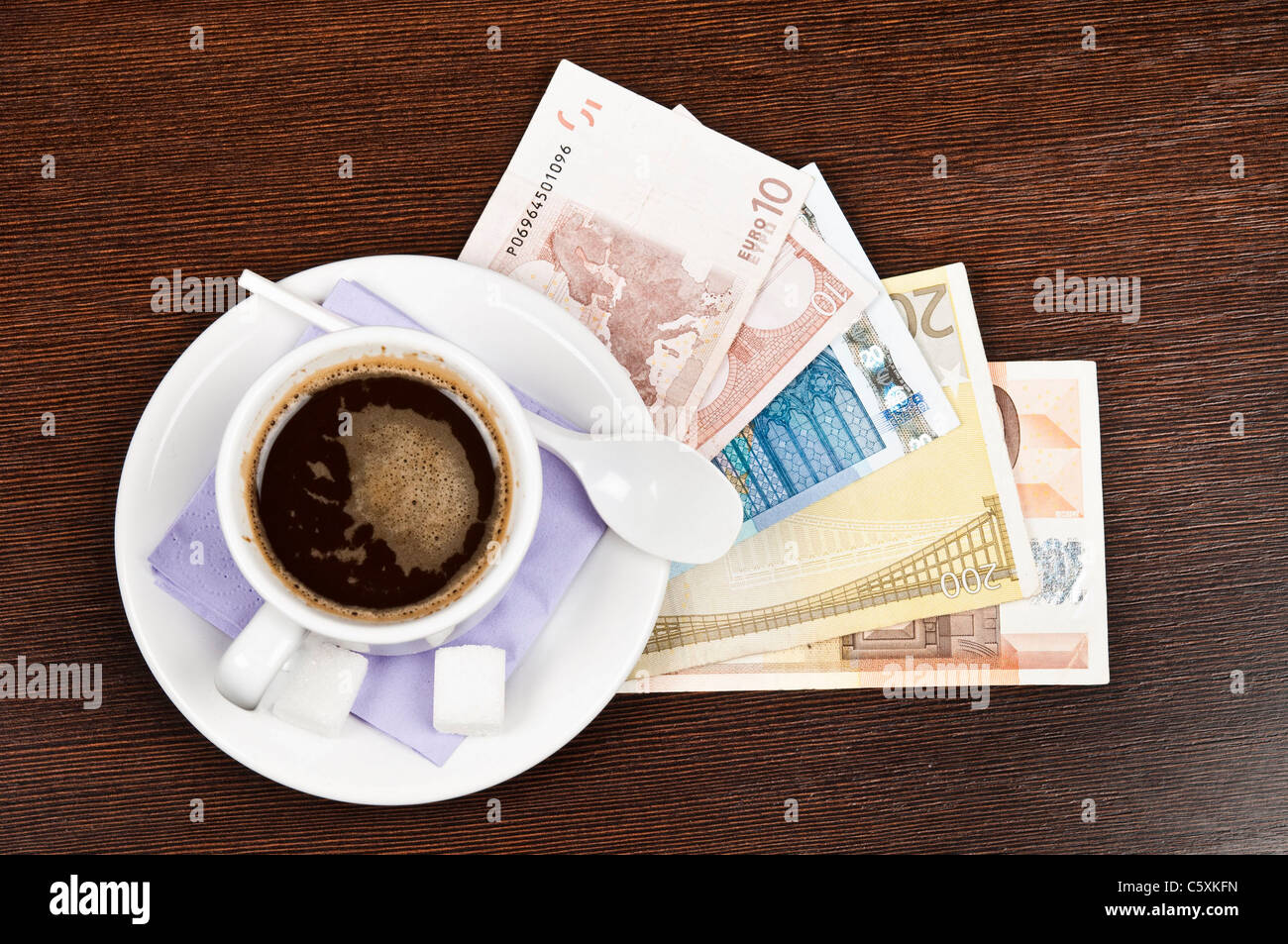 Cup of coffee on euro banknotes Stock Photo - Alamy