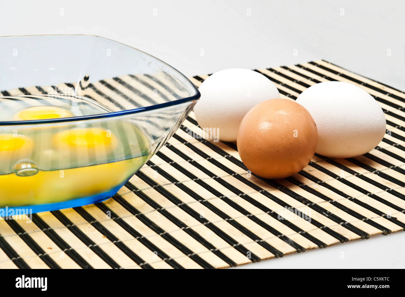 Eggs and yoke in transparent plate Stock Photo - Alamy