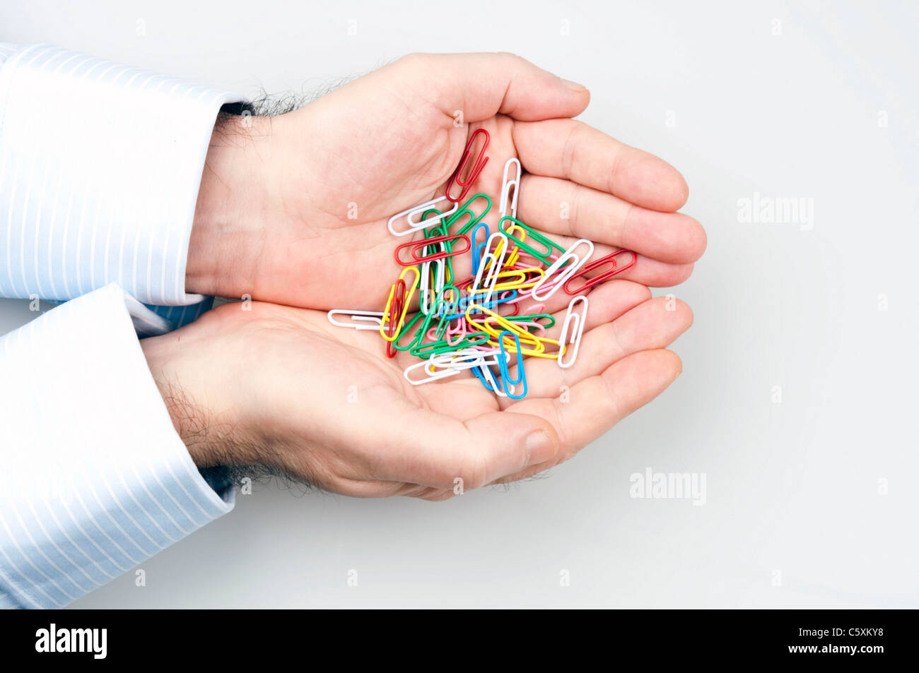 Paper clips in male hands Stock Photo - Alamy