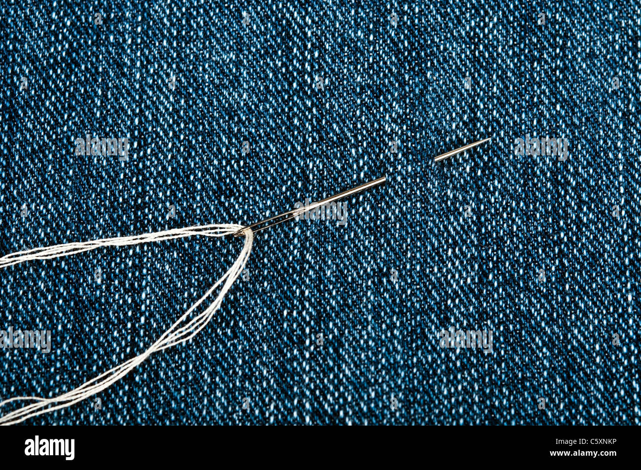 Thread on blue jeans material Stock Photo - Alamy