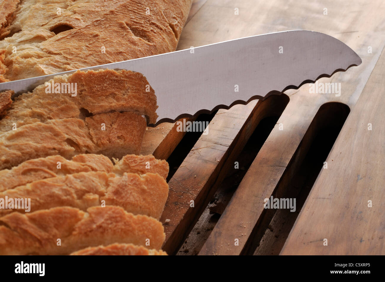 Cutting slices from bread loaf Stock Photo - Alamy