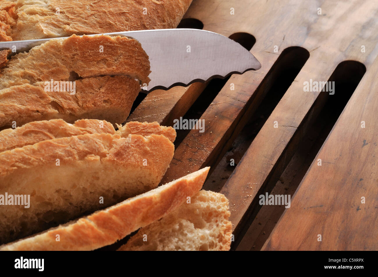 Cutting slices from bread loaf Stock Photo - Alamy