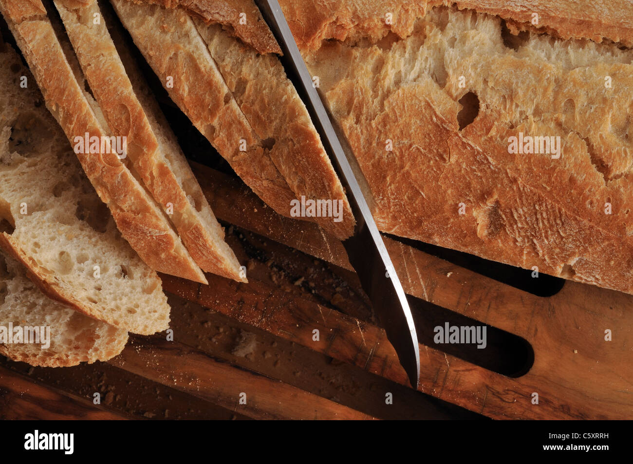 Cutting slices from bread loaf Stock Photo - Alamy
