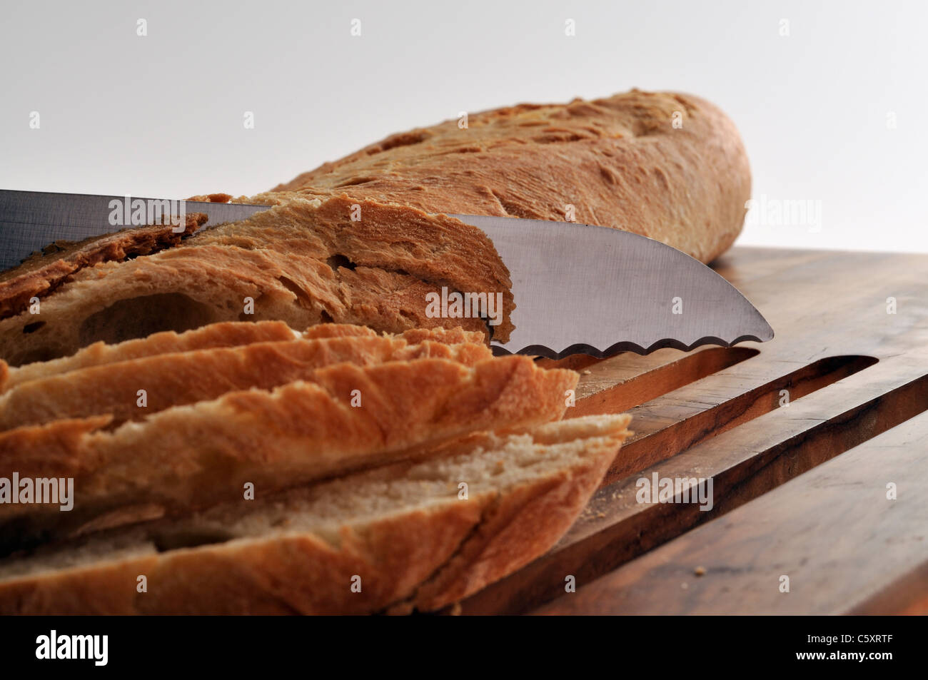 Cutting slices from bread loaf Stock Photo - Alamy