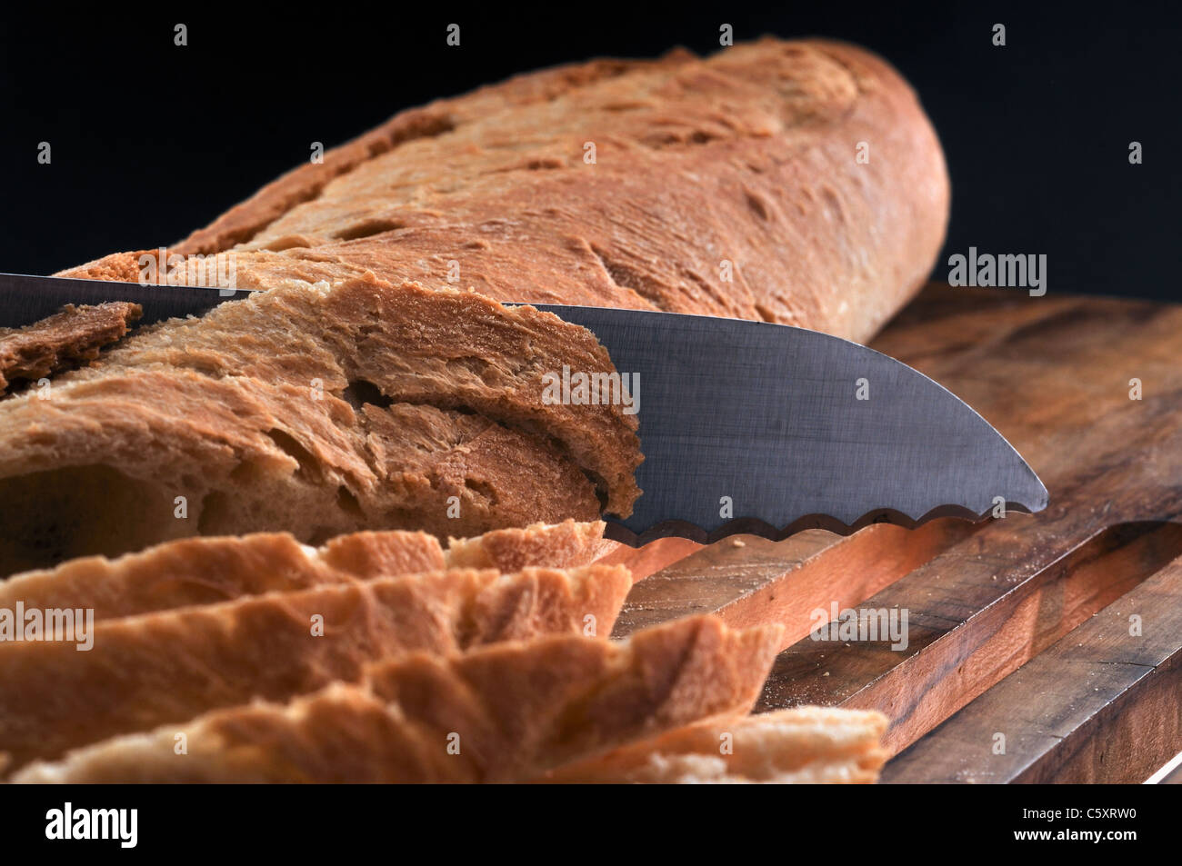Cutting slices from bread loaf Stock Photo - Alamy