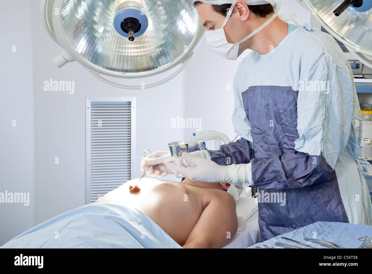 Surgeon performing operation on patient in operating room Stock Photo ... Surgeon performing operation on patient in operating room Stock Photo ...