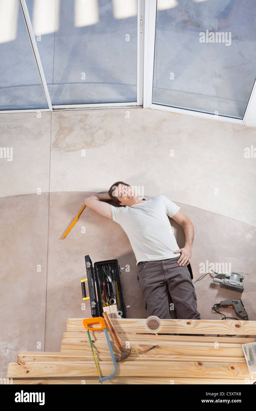Man laying on ground with home improvement tools Stock Photo - Alamy
