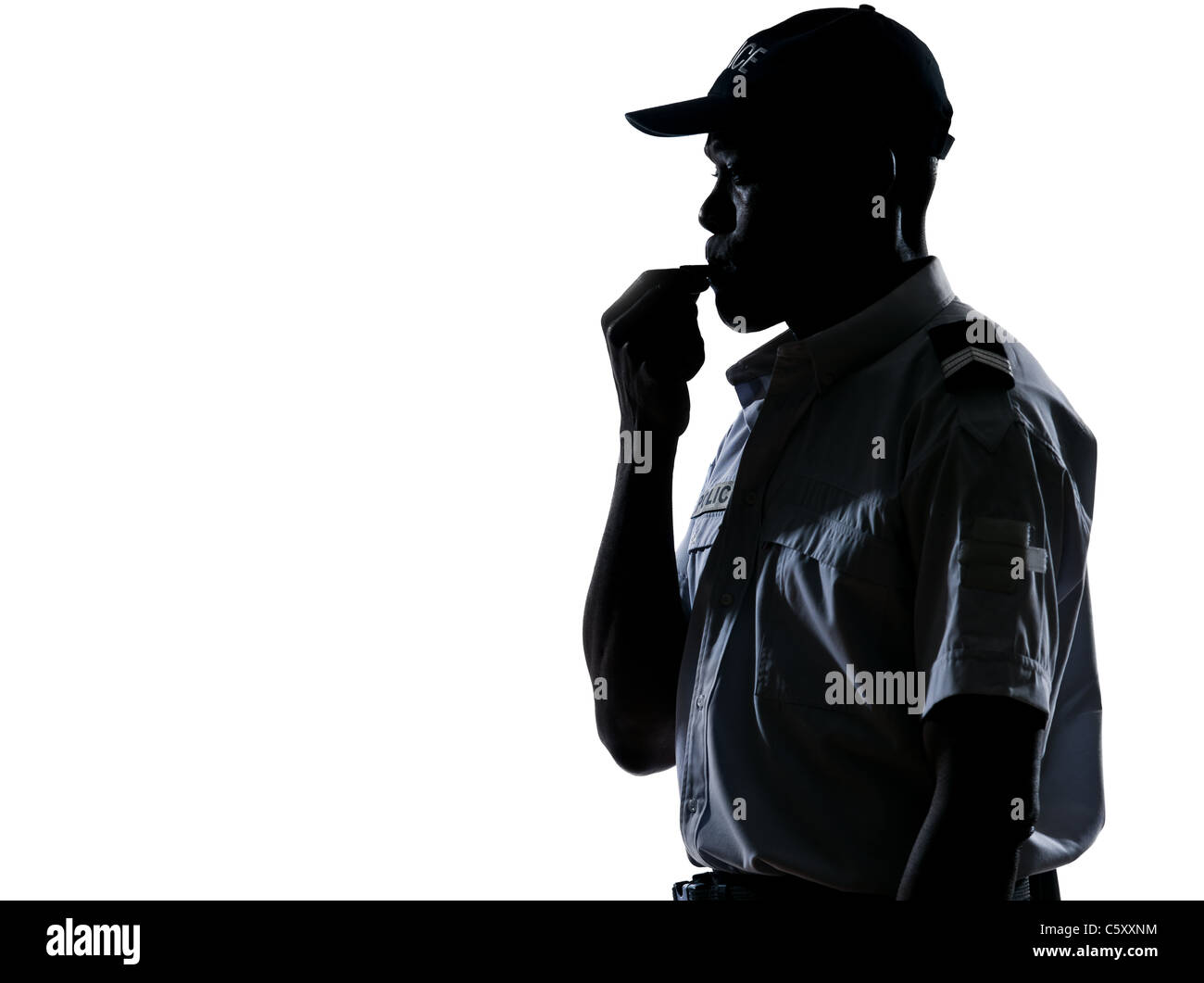 Side view of an afro American policeman blowing whistle in studio on ...