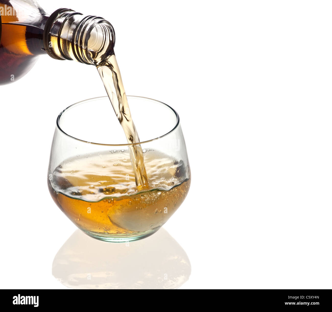 A glass of whiskey being poured on a white background Stock Photo - Alamy
