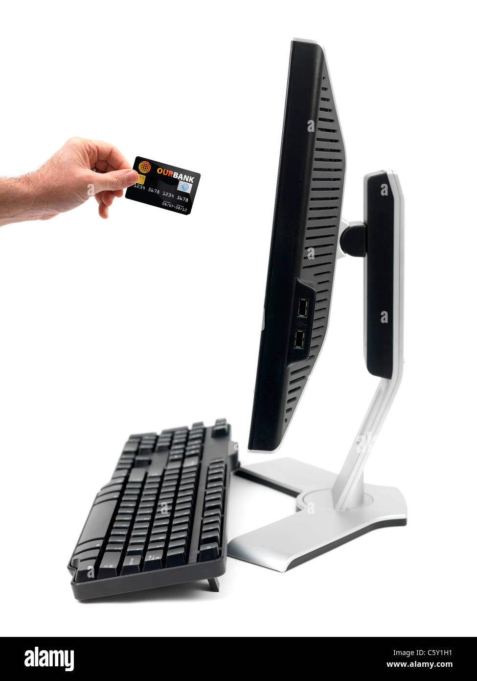 A desktop computer and a credit card isolated against a white ...