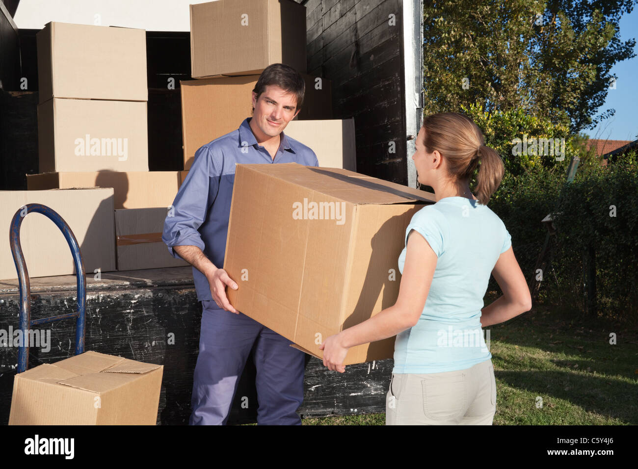 Couple carrying box into the truck while moving into new home Stock ...