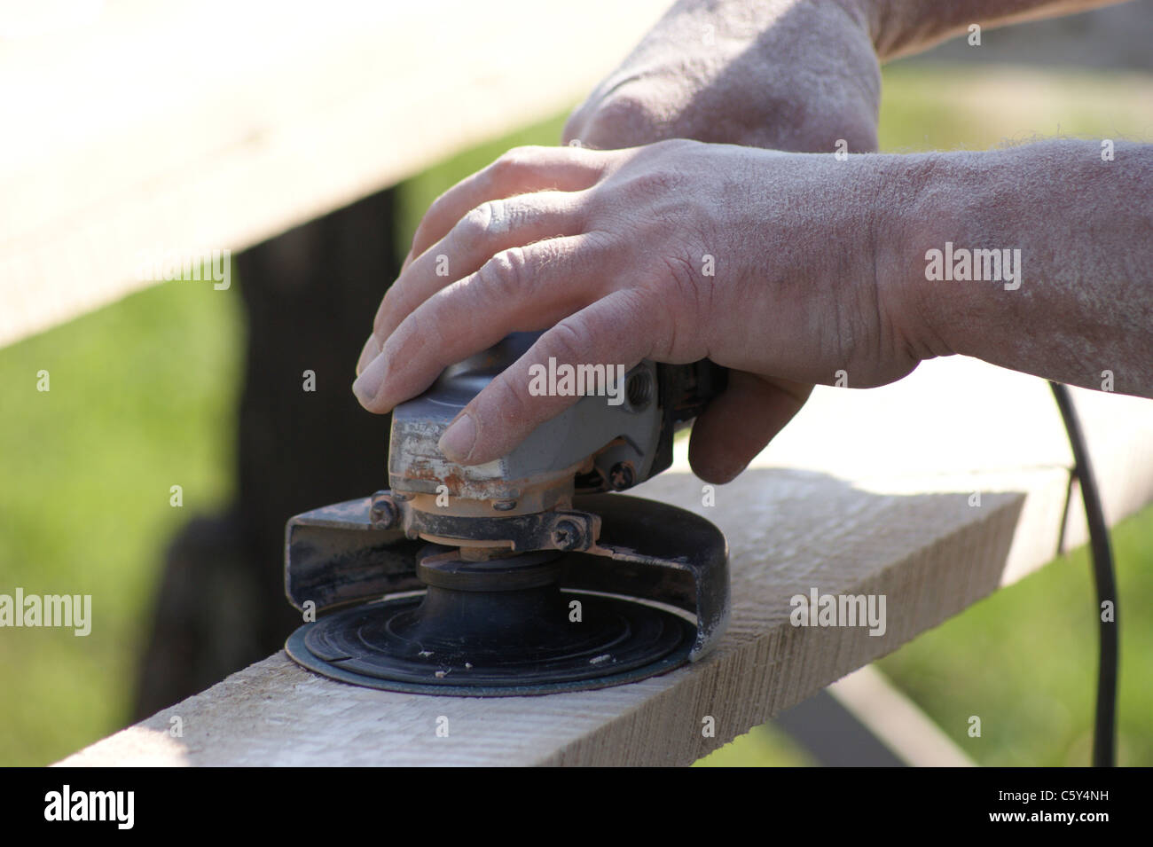 A wooden board is sanded with a grinder Stock Photo - Alamy