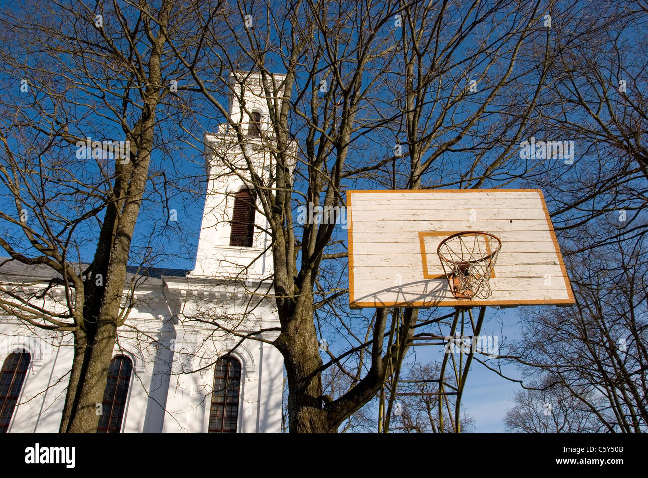 Old basketball board with an old tattered basketball net on the hoop ...
