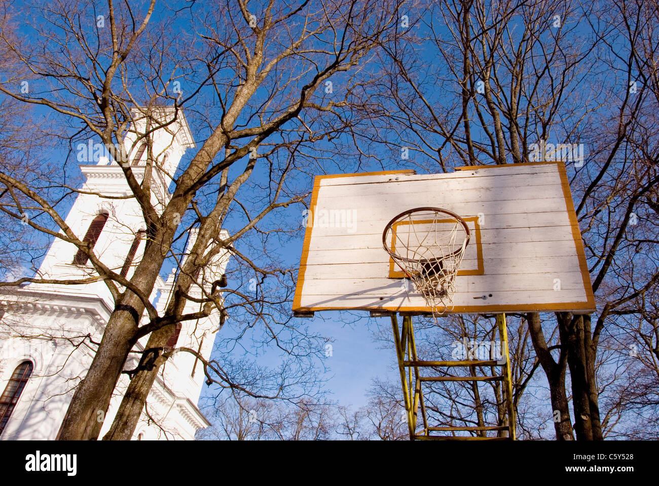 Old basketball board with an old tattered basketball net on the hoop ...