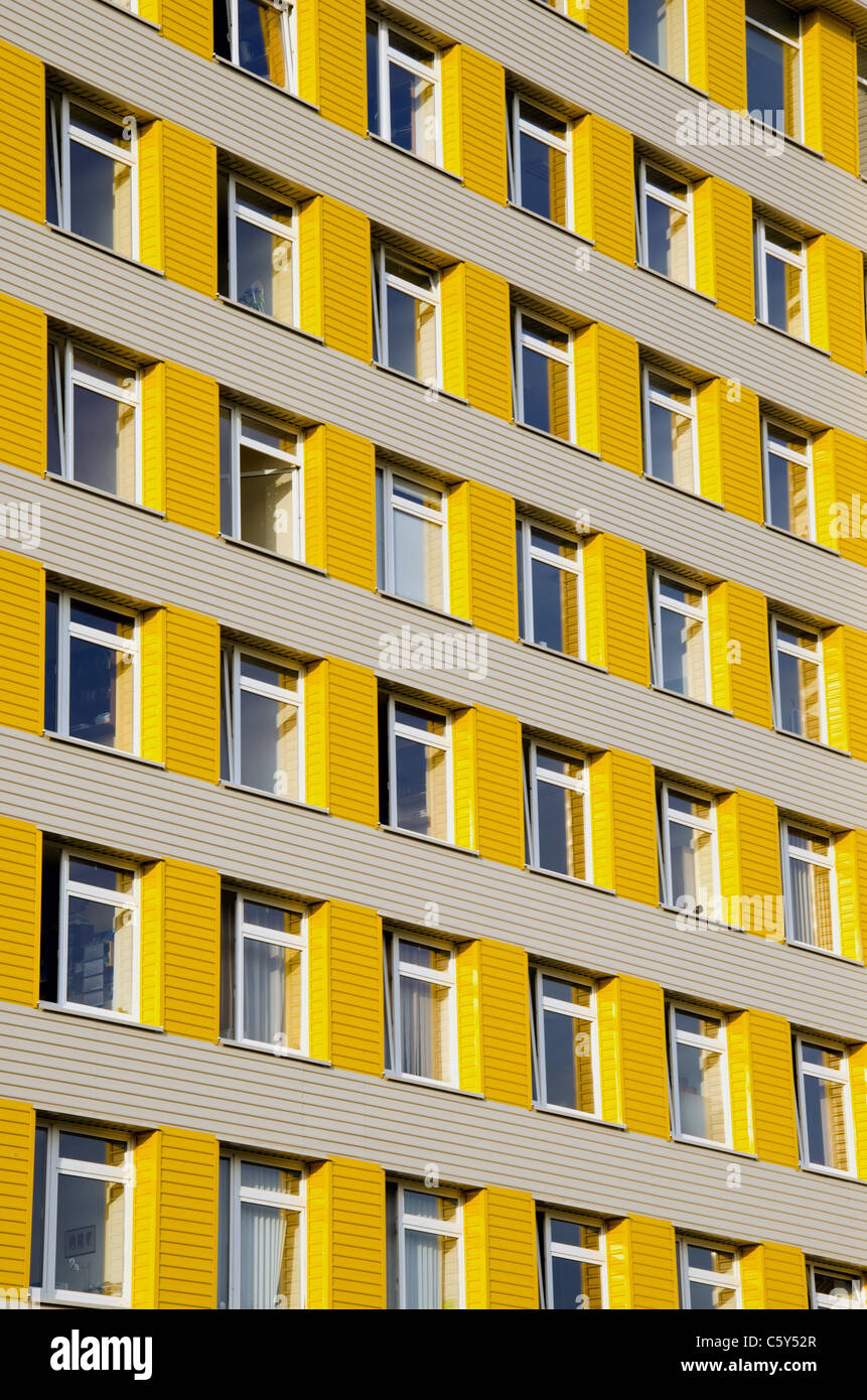 Fragment of yellow tall building with many windows Stock Photo - Alamy