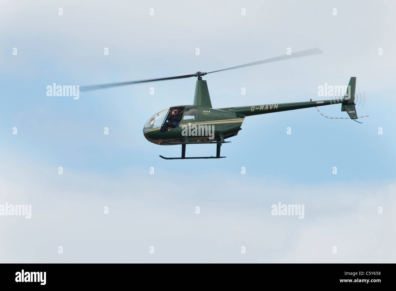 Photographer taking images from the open cockpit of a Robinson R44 ...