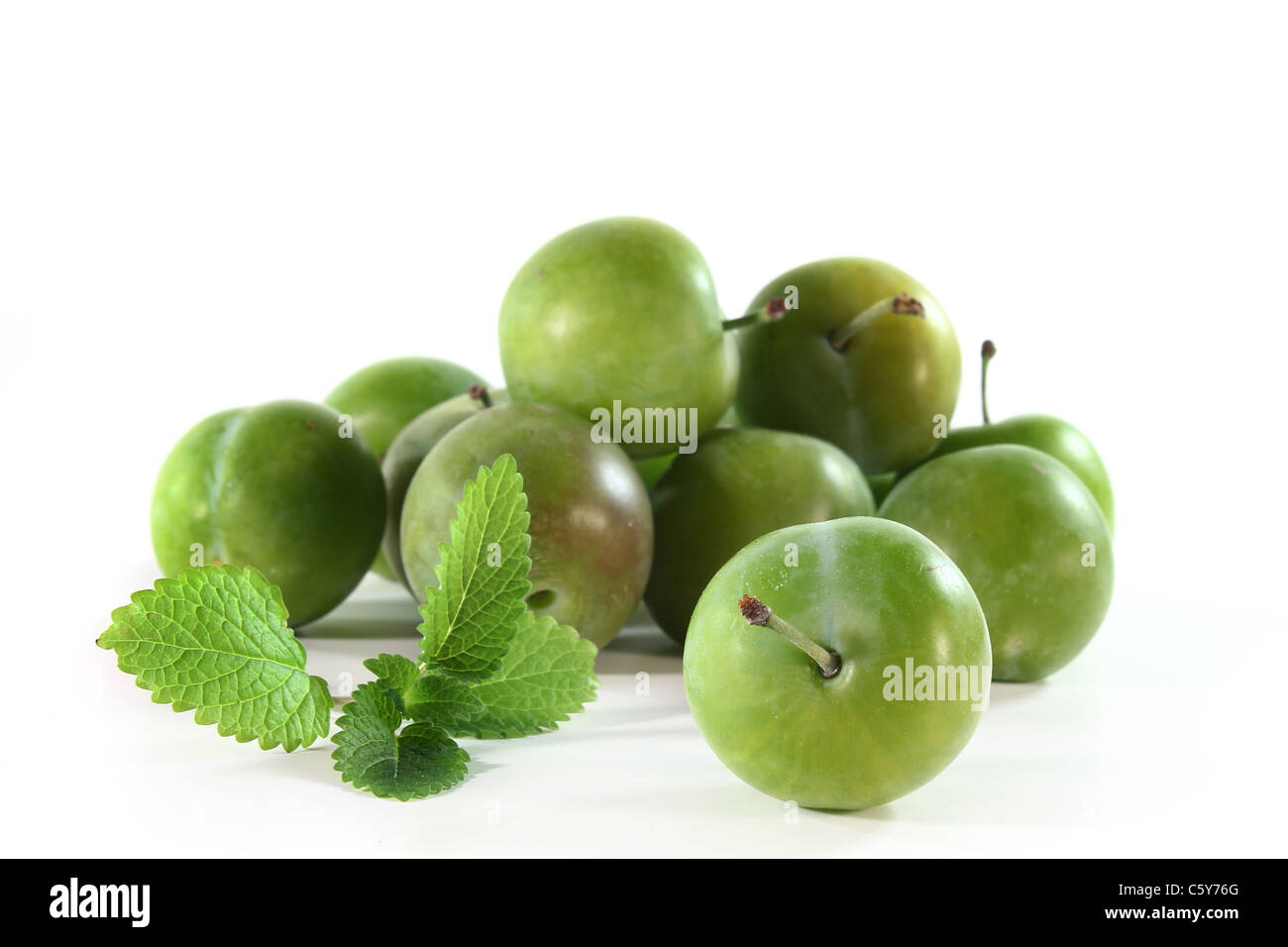 fresh green plums on a white background Stock Photo - Alamy