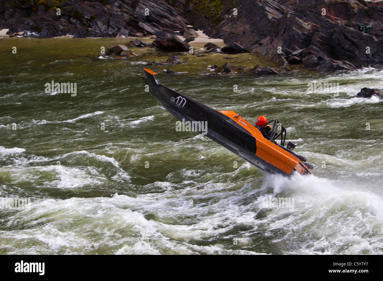 Black and orange number 177 boat leaps out of the rapids as it races ...