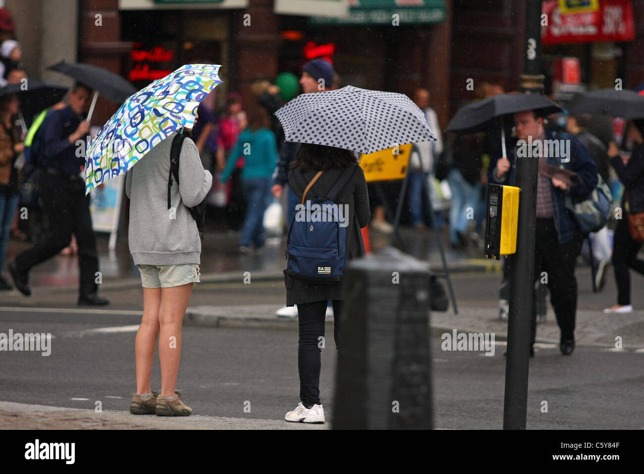 people sheltering from the rain under their umbrellas, in London Stock ...