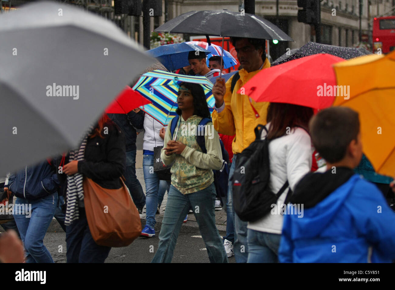 people sheltering from the rain under their umbrellas, in London Stock ...