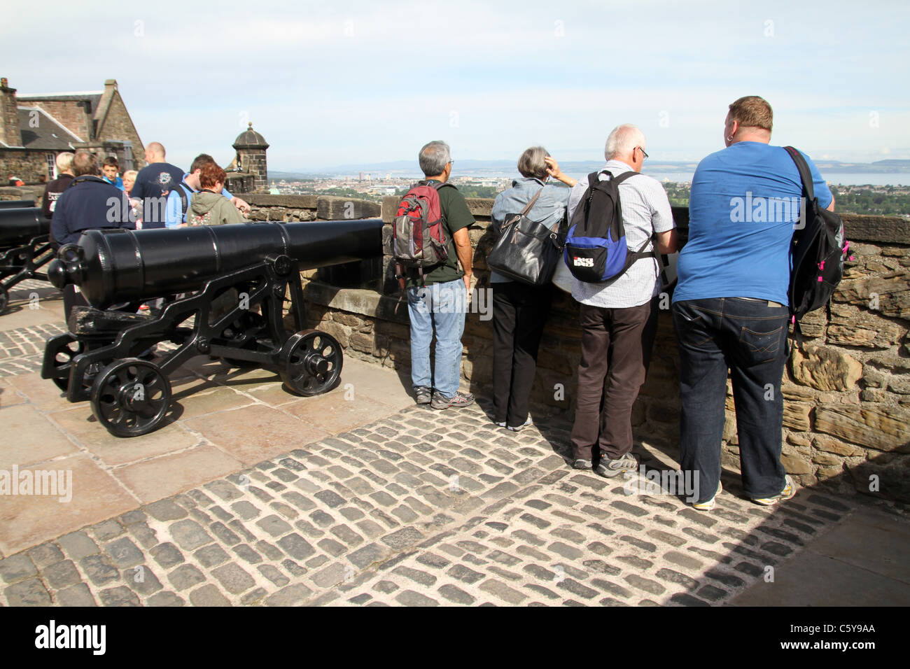 Scotland. Tourists visiting the ancient Edinburgh castle with cannons ...