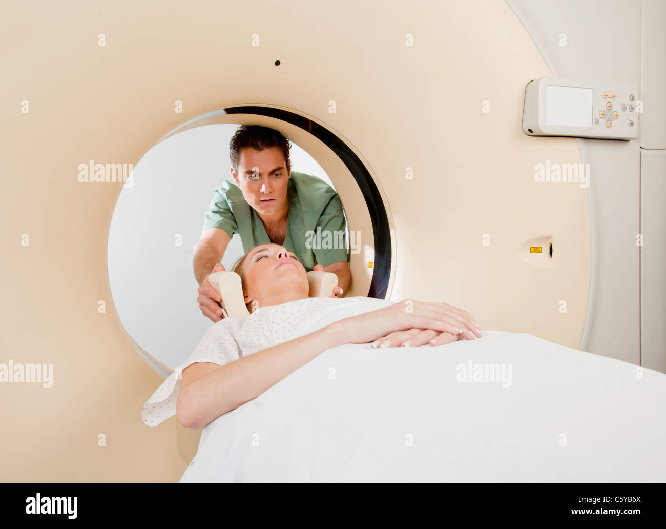 A CT scan technician aligning a patient in the machine Stock Photo - Alamy