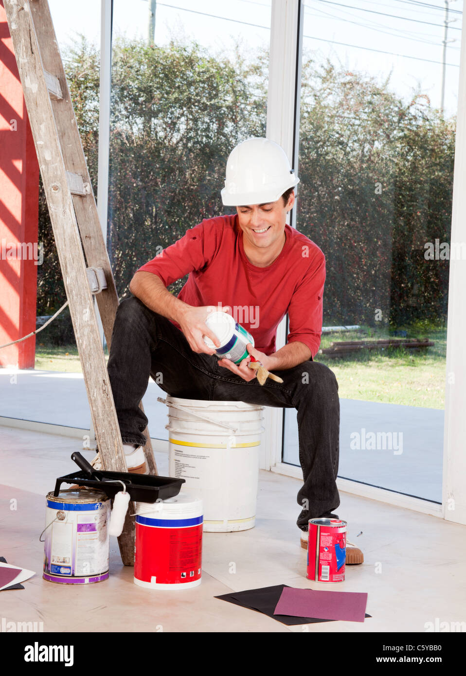 A man with a hard hat, indoors ready to paint Stock Photo - Alamy