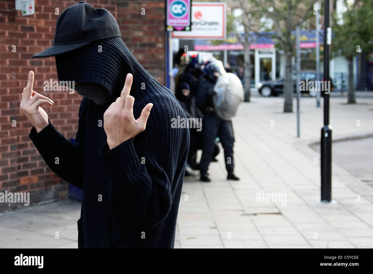 A masked troublemaker poses outside Enfield Station on Sunday afternoon ...