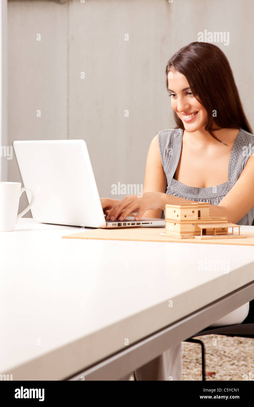 An architect working on a computer with house model on the desk Stock ...
