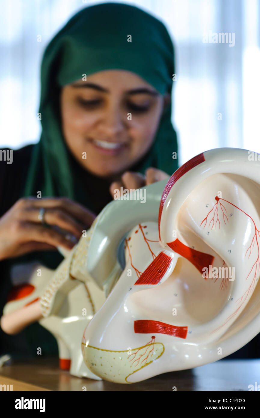 Female Asian audiology and deafness student aged 18-20 years wearing ...