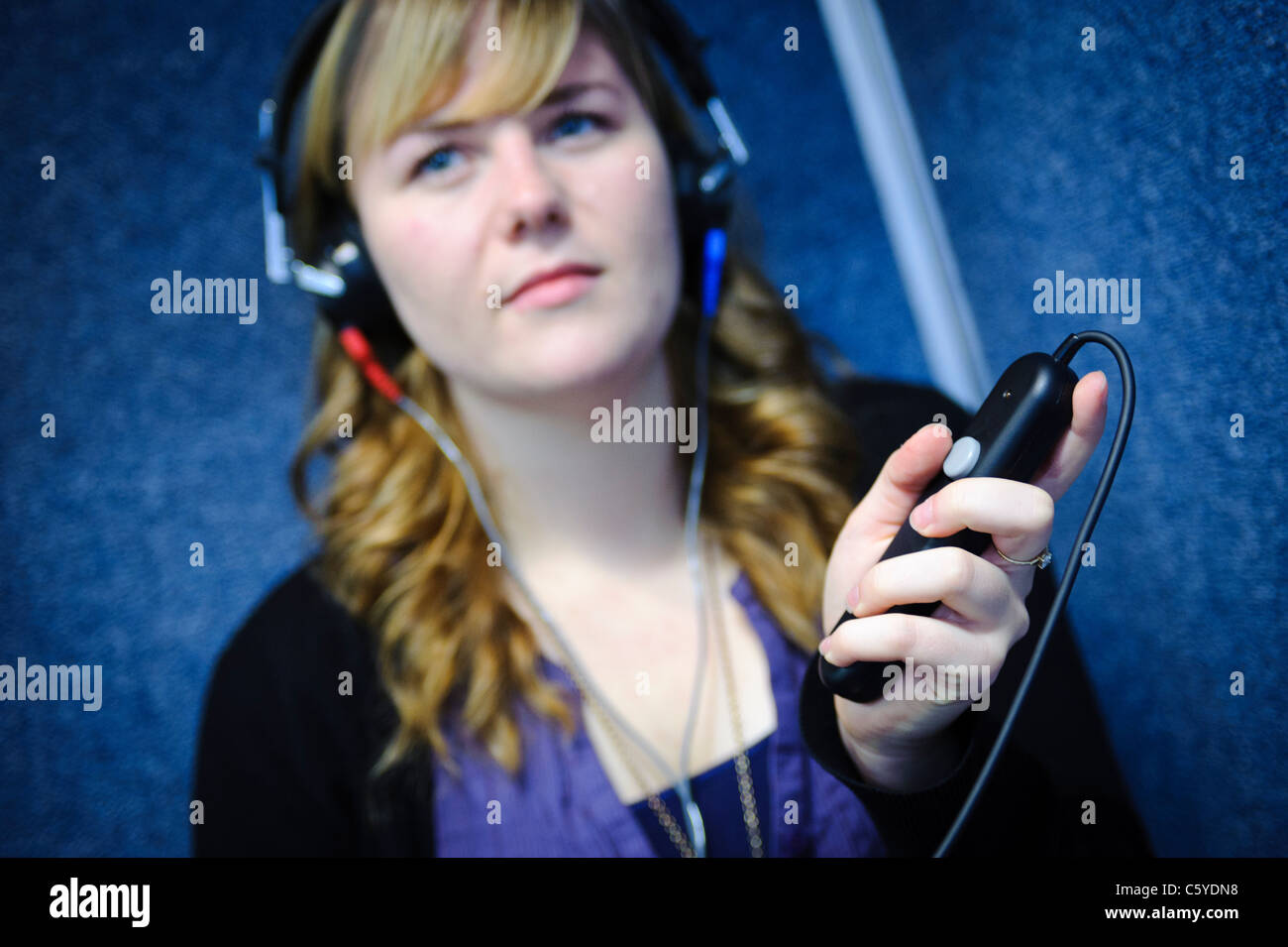 Audiology and deafness sound booth with young female 18-20 wearing ...