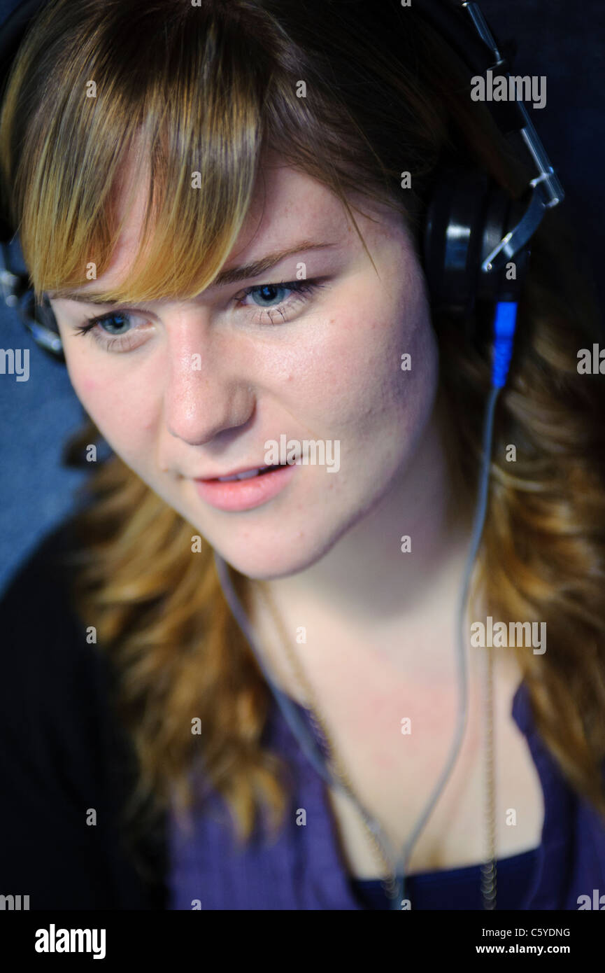 Audiology and deafness sound booth with young female 18-20 wearing ...