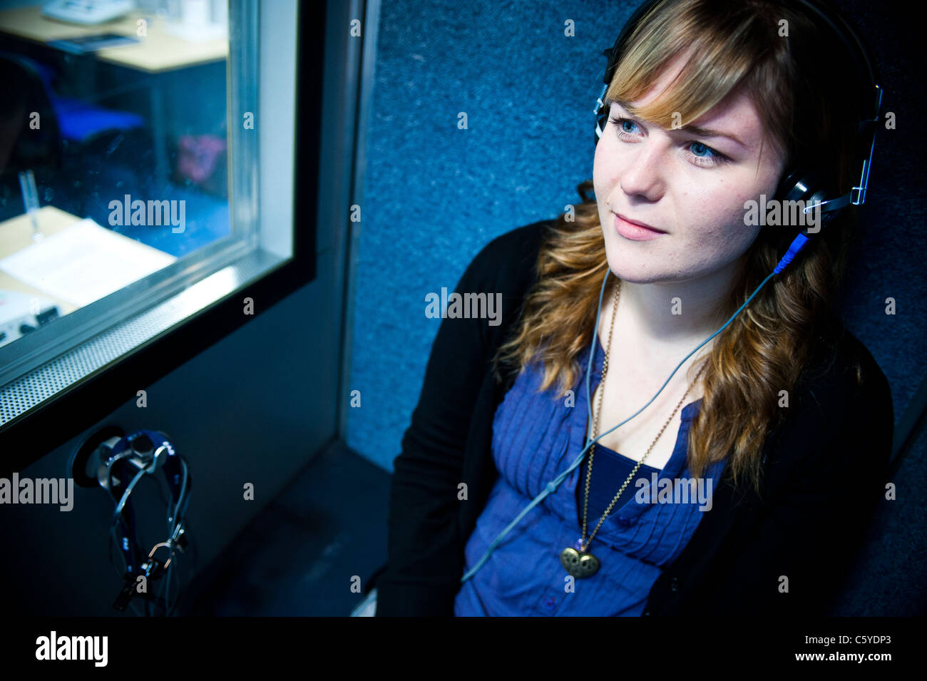 Audiology and deafness sound booth with young female 18-20 wearing ...