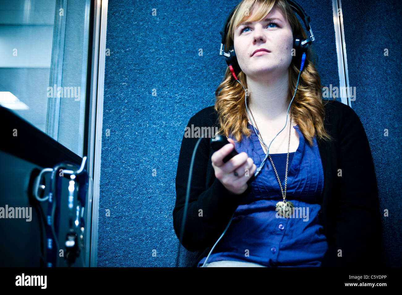 Audiology and deafness sound booth with young female 18-20 wearing ...