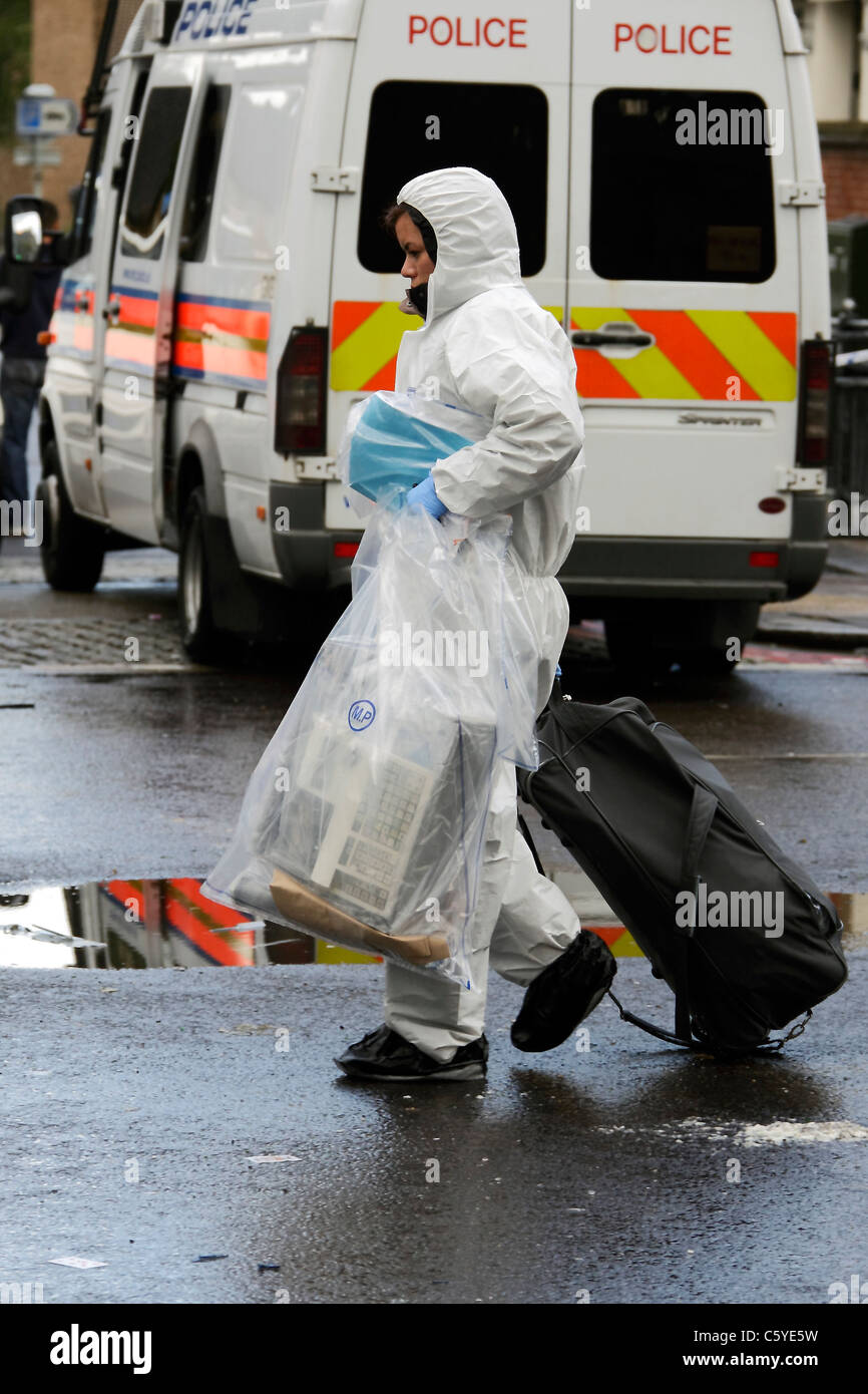 Crime Scene Investigator carries a recovered cash till in a plastic ...