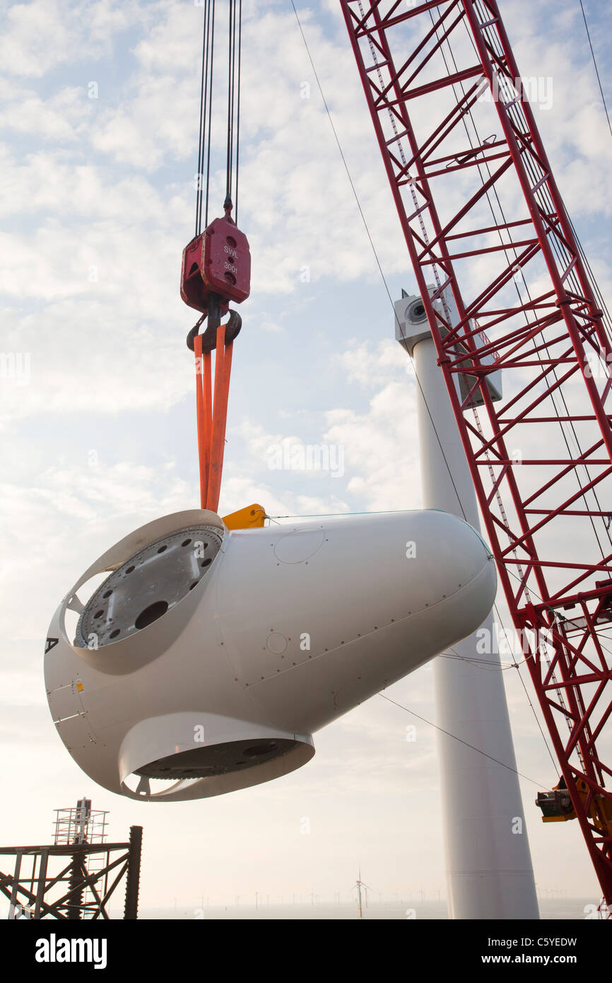 A nose cone being lifted into place on a wind turbine off the jack up ...