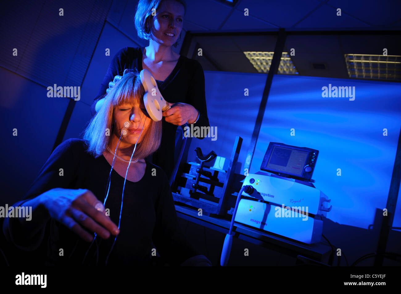 neuroscientist using key shaped paddle to perform transcranial magnetic ...