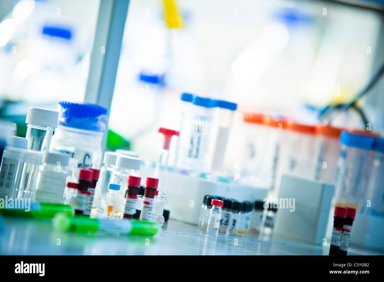 glass test tubes with colored tops on bench side in science laboratory ...